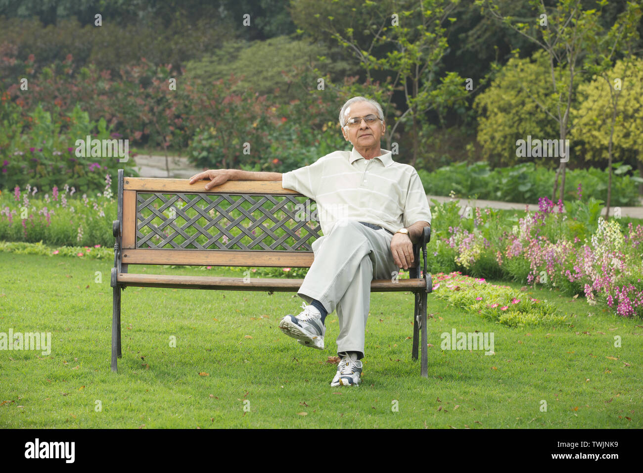 Old man sitting on a park bench Stock Photo - Alamy