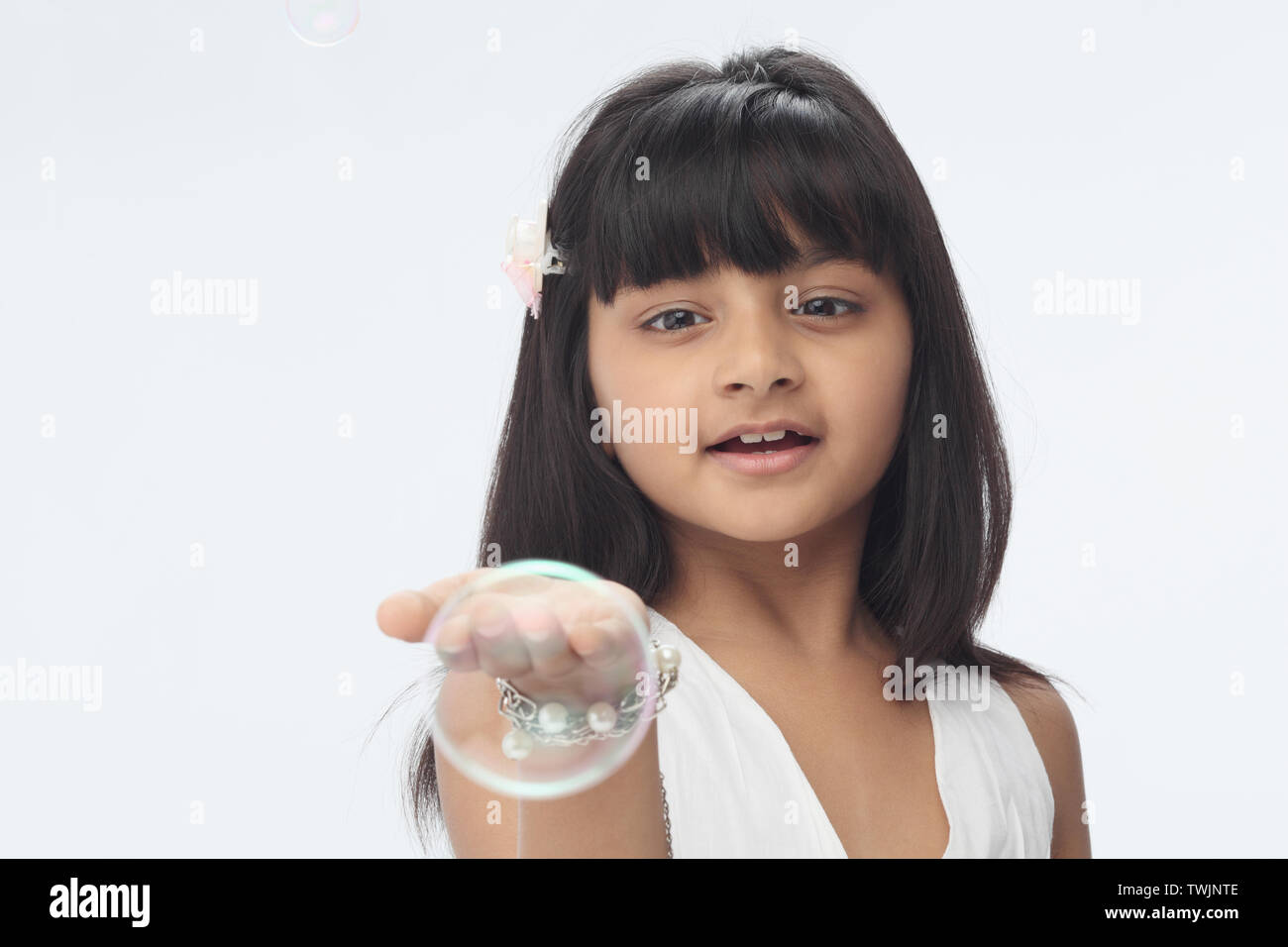 Girl holding hands beneath floating bubbles Stock Photo - Alamy