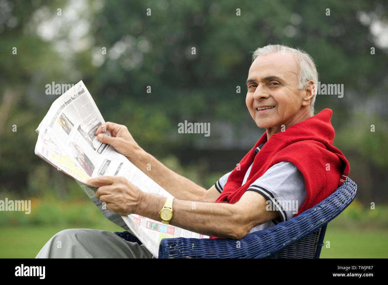 Old man reading a newspaper and smiling Stock Photo - Alamy
