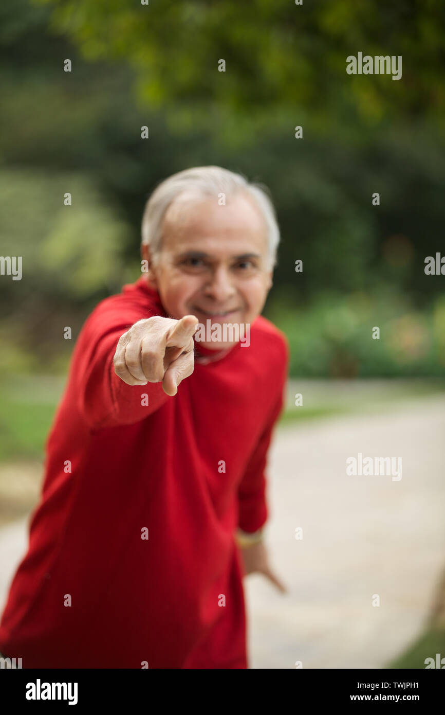 Old man pointing toward camera and smiling Stock Photo - Alamy