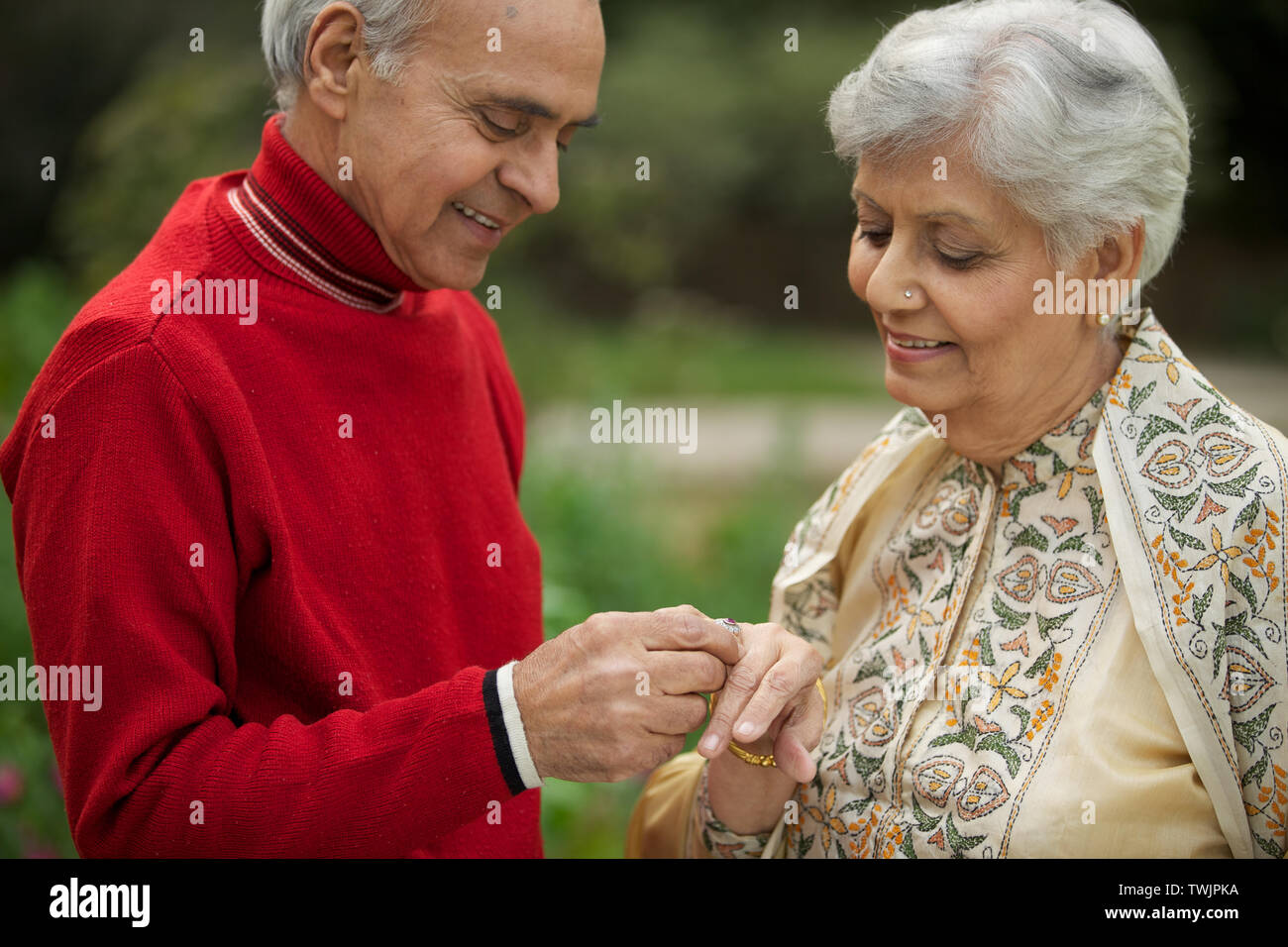 Old man placing ring on woman finger Stock Photo - Alamy