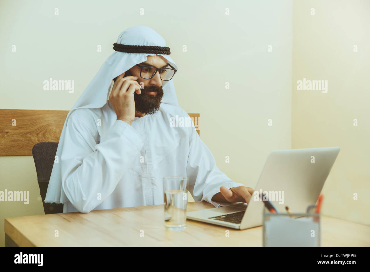 Arab saudi businessman working online with a laptop and tablet in his ...