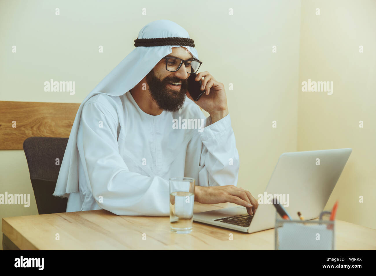 Arab saudi businessman working online with a laptop and tablet in his ...