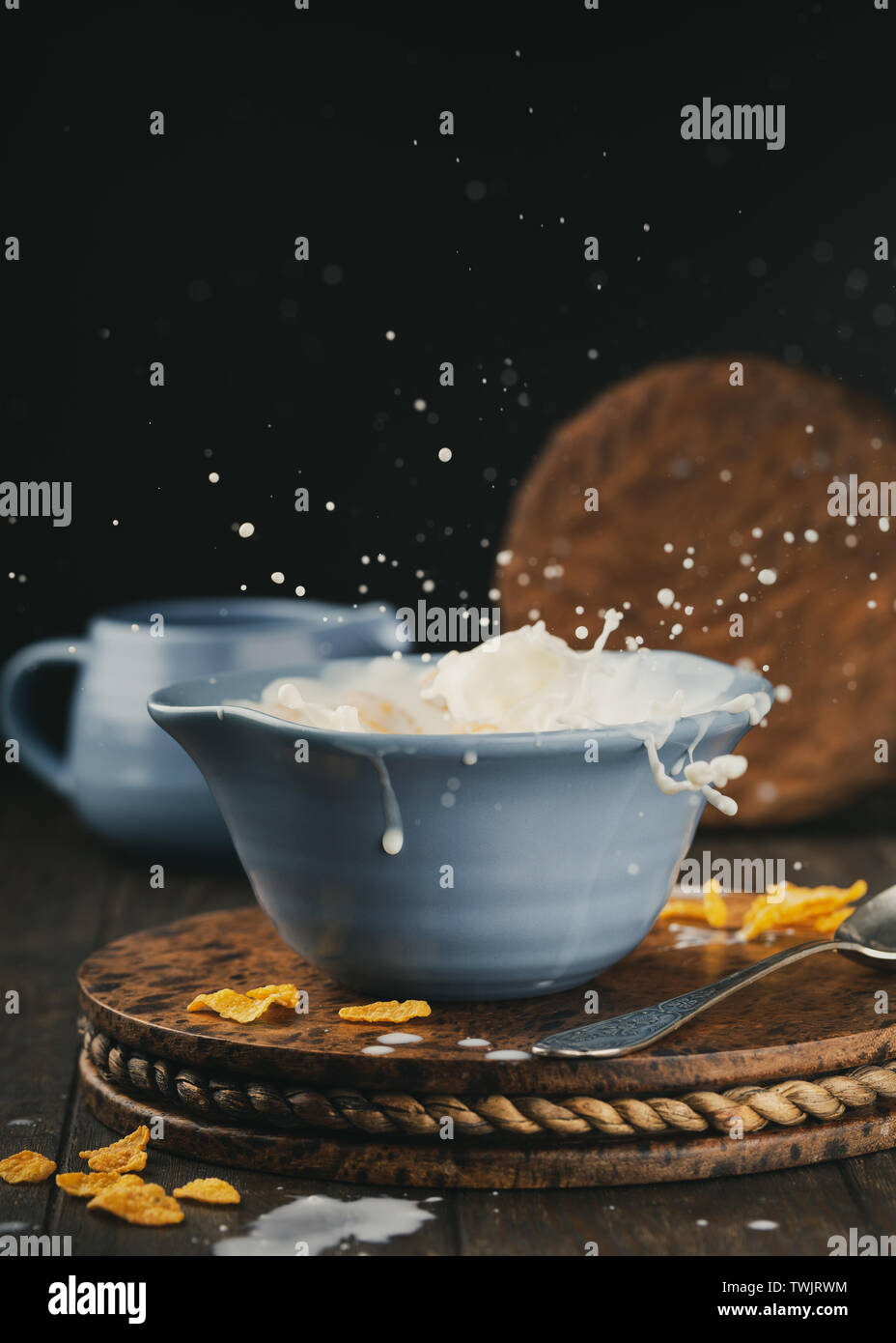 Blue bowl of corn flakes with milk splash Stock Photo - Alamy