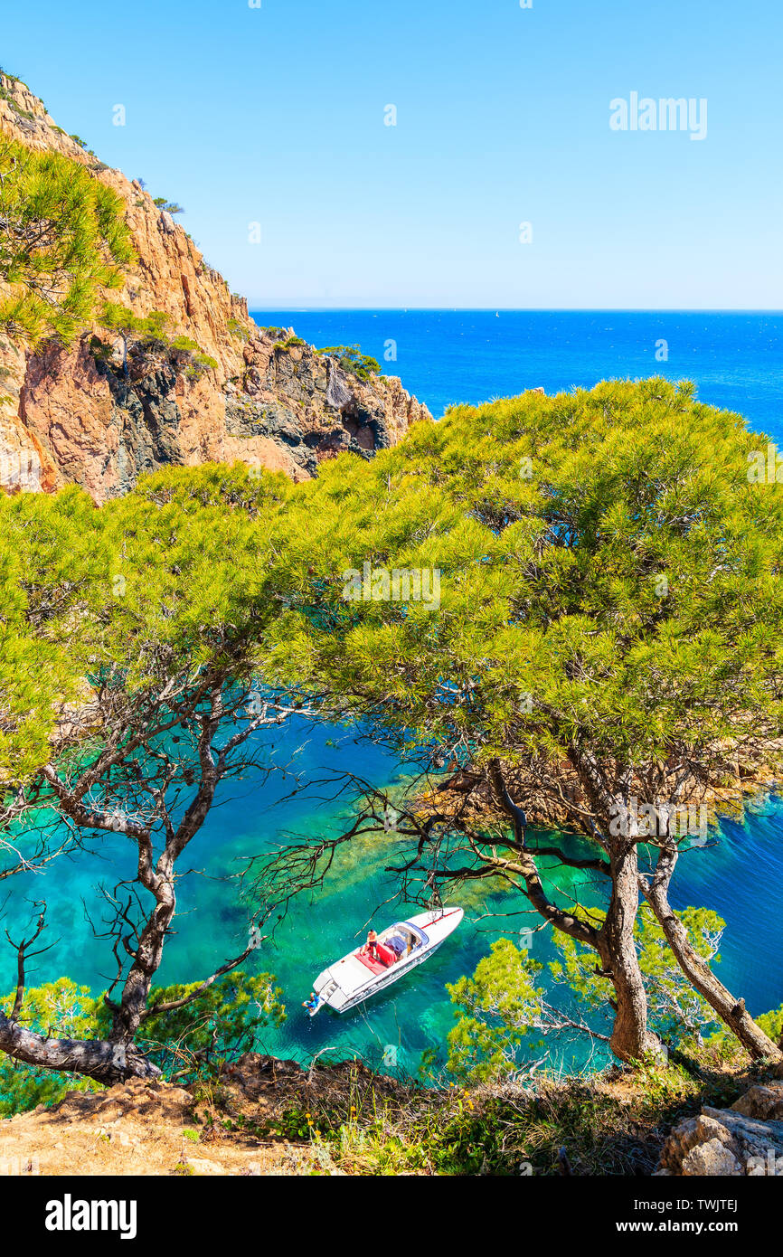 White motorboat in beautiful sea cove of Cala Marquesa with green pine ...