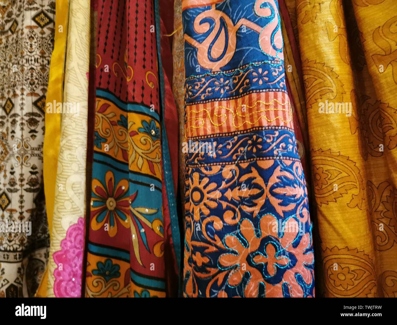 many colors indian fabric clothes at the market detail Stock Photo - Alamy