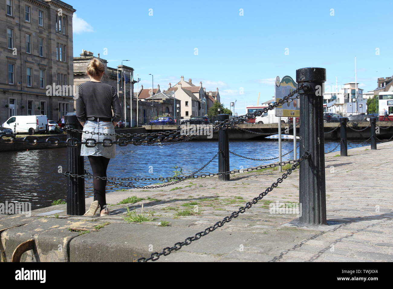 Woman looking into the Leith docks Stock Photo - Alamy