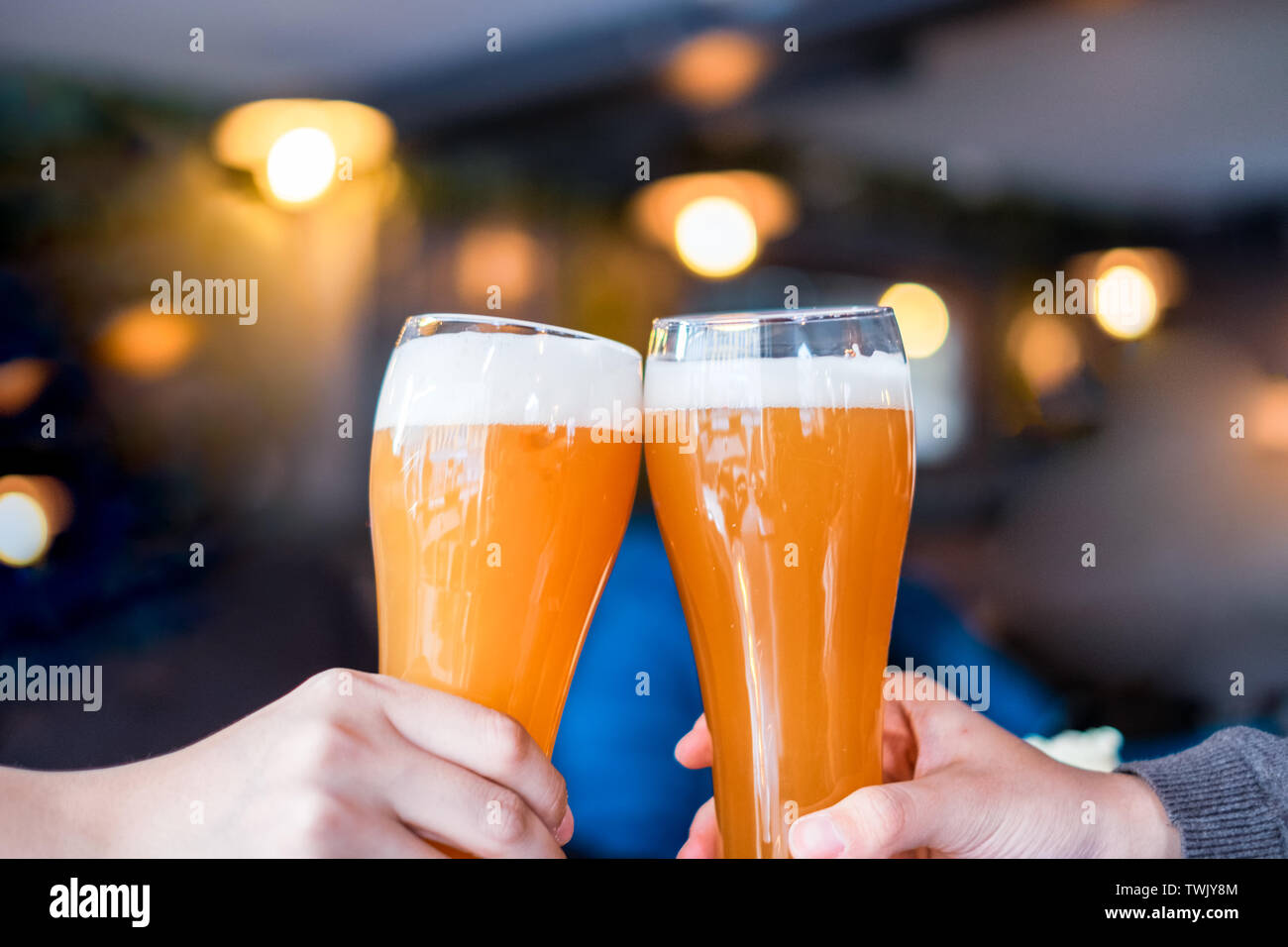 Enjoy clinking draft beer with friends in pub Stock Photo - Alamy