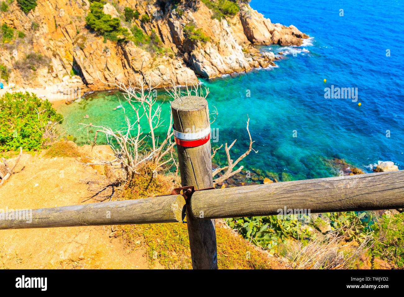 Trail post with white and red sign marking path in Tossa de Mar town ...