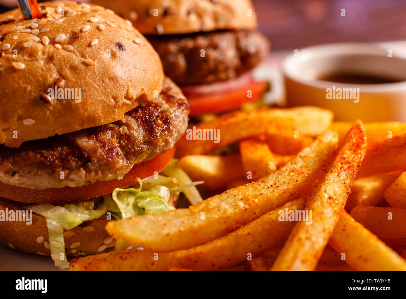 Clos up Two mini burgers in the restaurant. Sesame bun, meat Patty ...