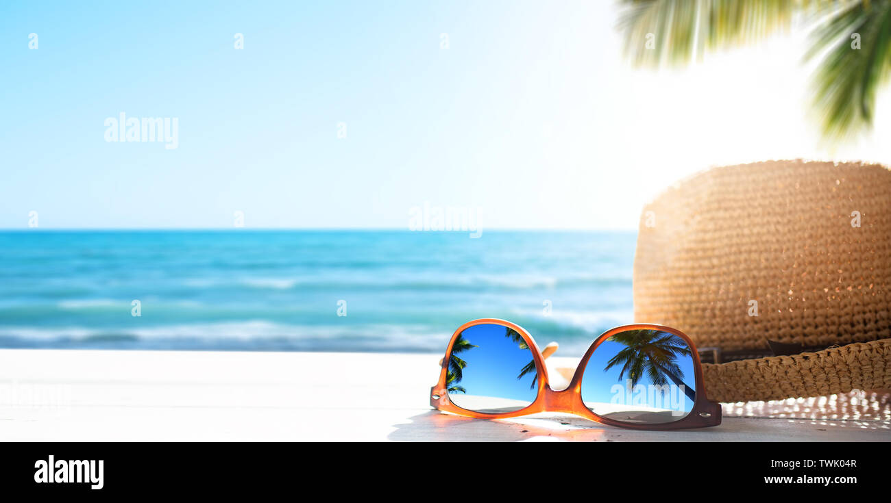 Sunny tropical beach vacation background; glasses and palm tree reflex ...