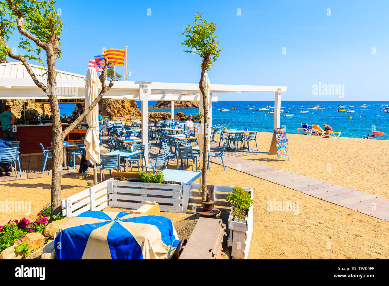 TOSSA DE MAR, SPAIN - JUN 3, 2019: People dining in restaurant on sandy ...