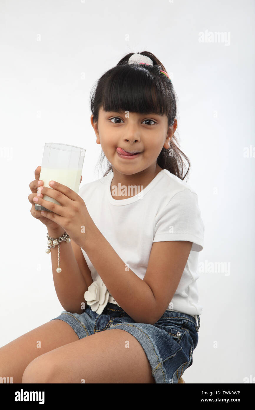 Girl licking milk off upper lip Stock Photo - Alamy