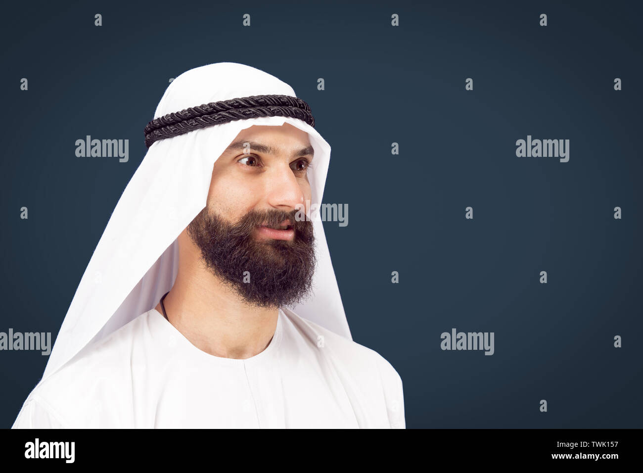 Half-length portrait of arabian saudi businessman on dark blue studio ...