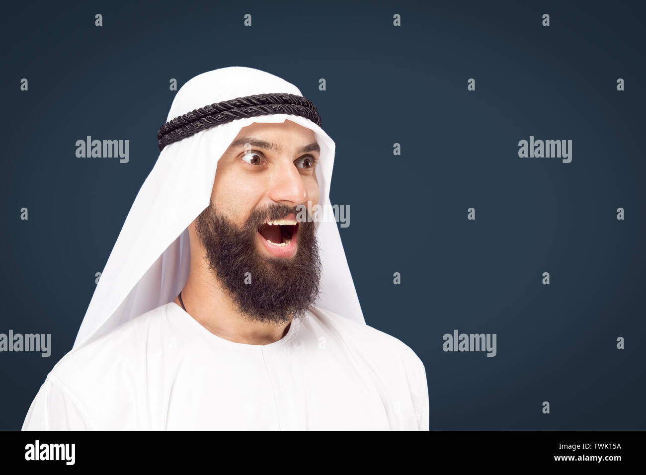 Half-length portrait of arabian saudi businessman on dark blue studio ...