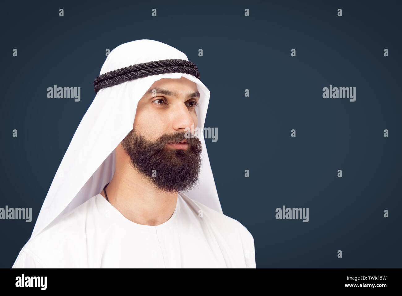 Half-length portrait of arabian saudi businessman on dark blue studio ...