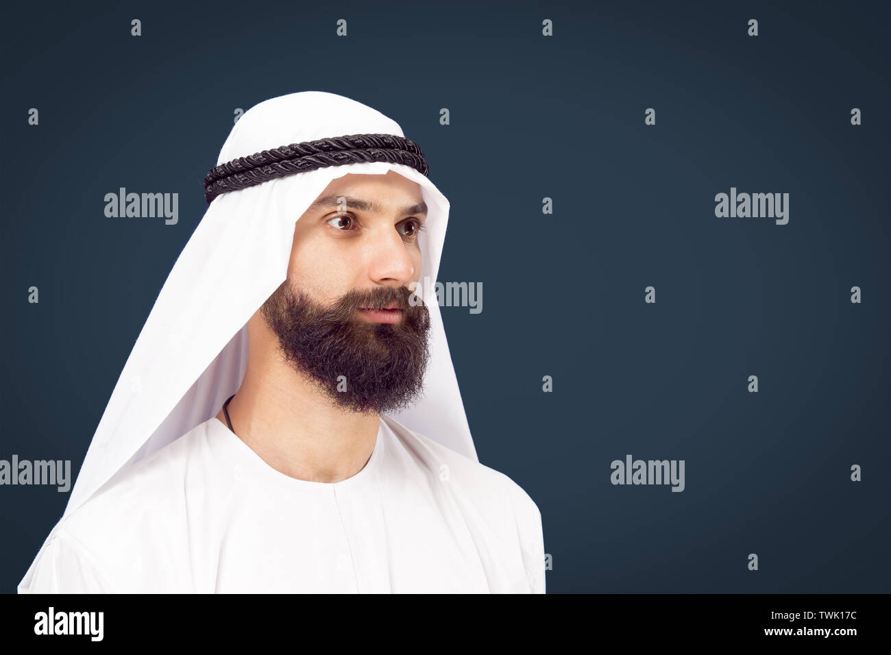 Half-length portrait of arabian saudi businessman on dark blue studio ...