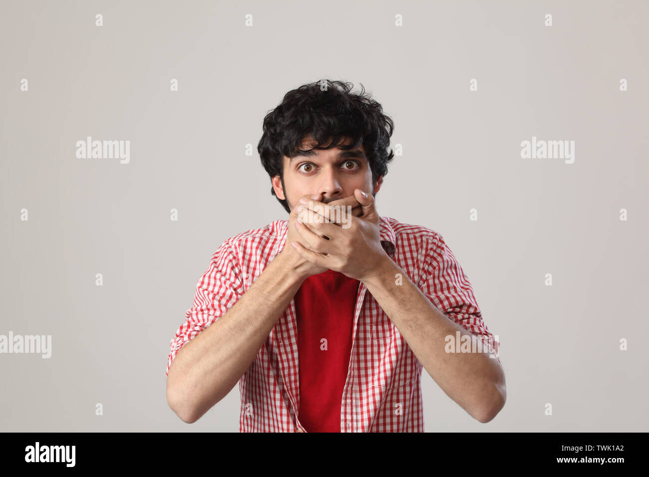 Man covering mouth with hands Stock Photo - Alamy