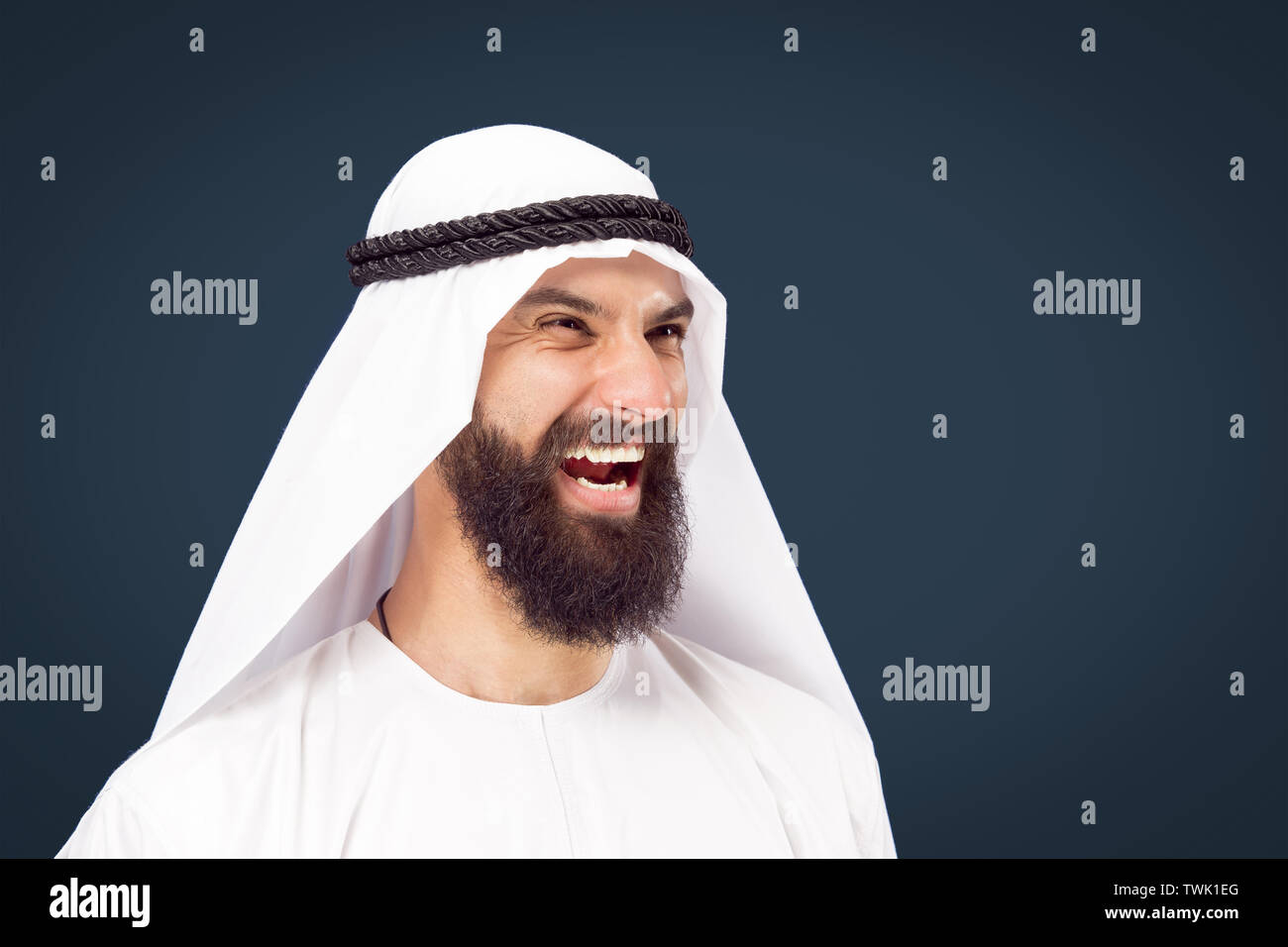 Half-length portrait of arabian saudi businessman on dark blue studio ...