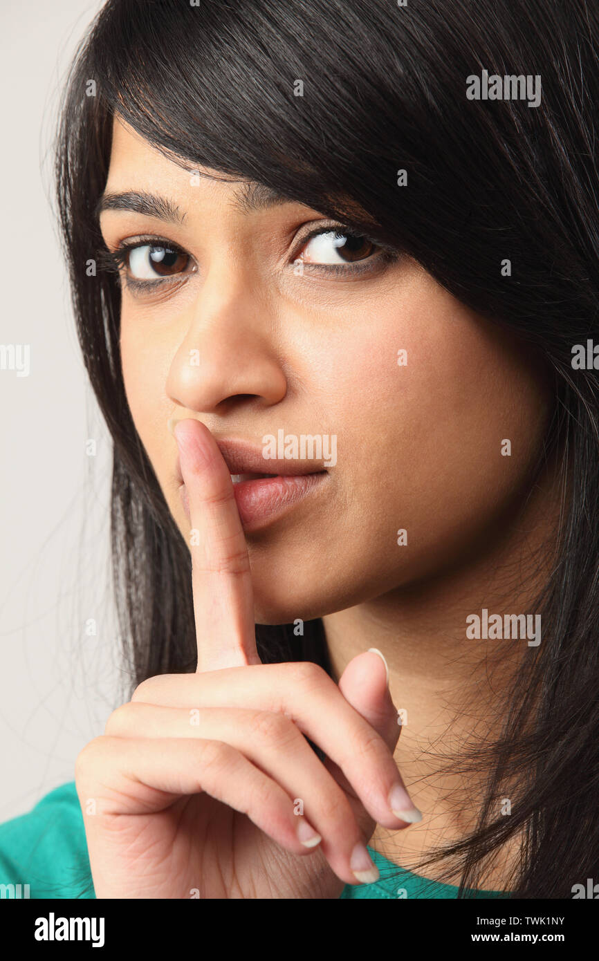 Portrait of a woman with a finger on lips Stock Photo - Alamy