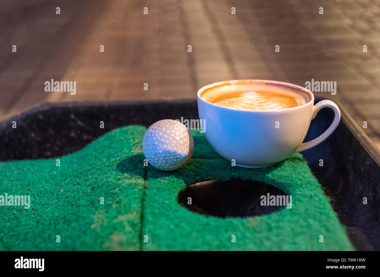 Hot latte coffee cup with golf ball on putting green mat Stock Photo ...