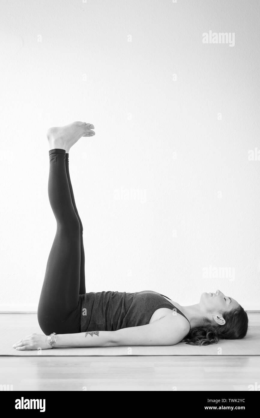 Side view of a young European brunette woman in her 30s practicing the ...