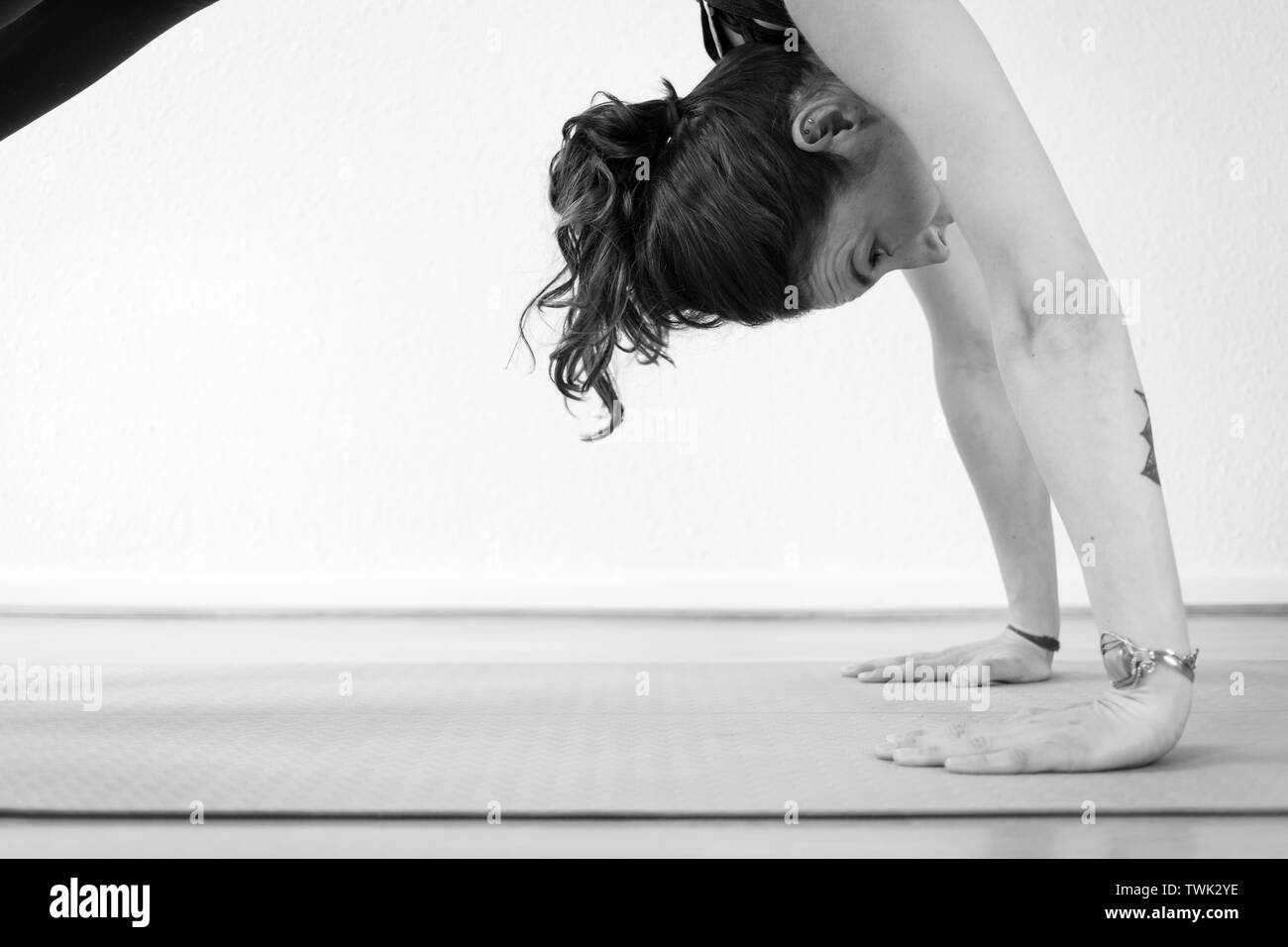 European brunette doing a back bend Wheel Pose or Upward Bow Pose, also ...