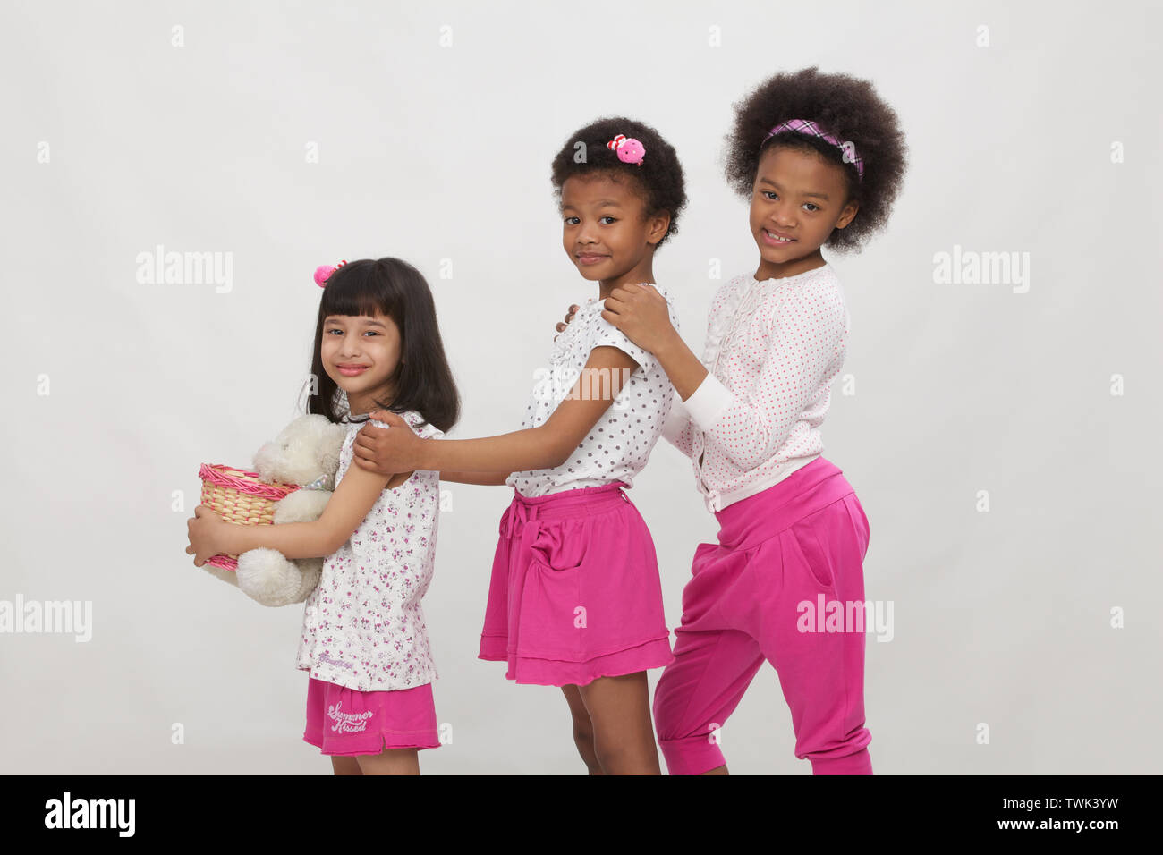 Portrait of three girls standing in a row Stock Photo - Alamy