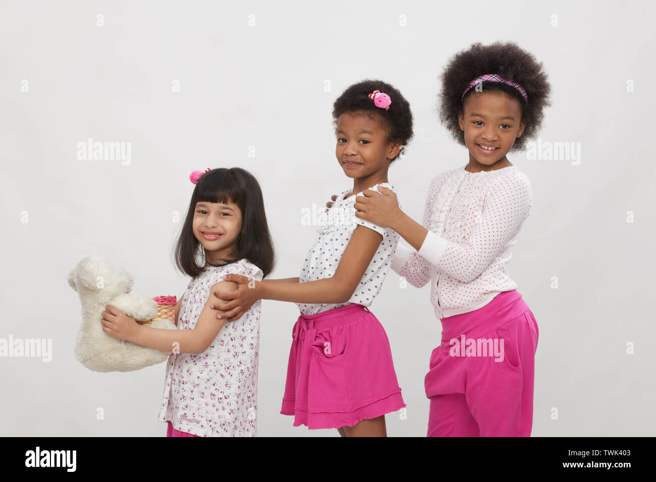 Portrait of three girls standing in a row Stock Photo - Alamy