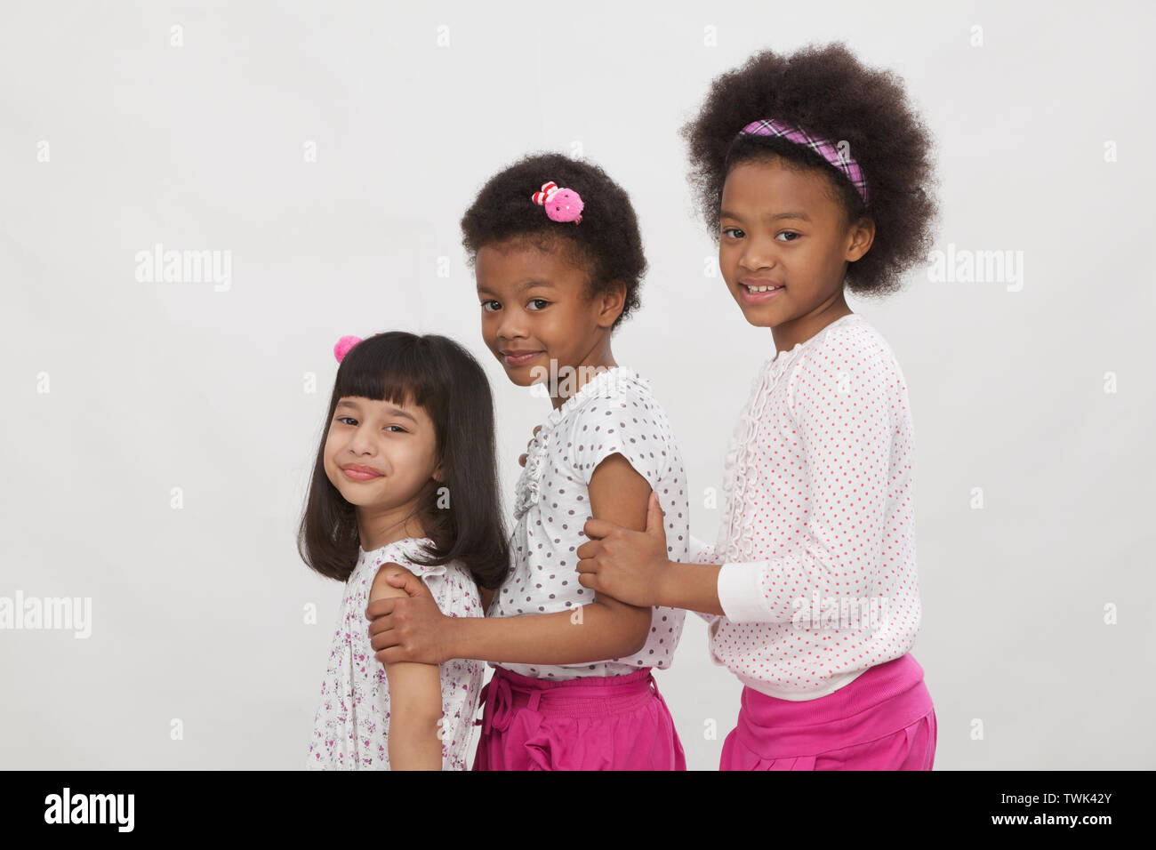 Portrait of three girls standing in a row Stock Photo - Alamy