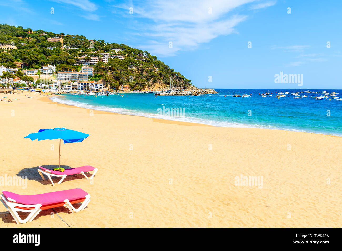 Sunbeds with umbrella on sandy beach in Llafranc village, Costa Brava ...