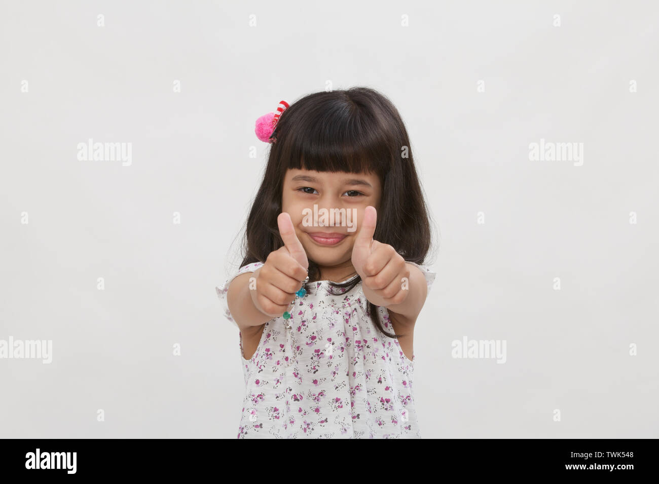 Portrait of a girl showing thumbs up with both hands Stock Photo - Alamy