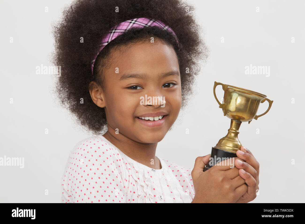Portrait of a girl holding a trophy and smiling Stock Photo - Alamy
