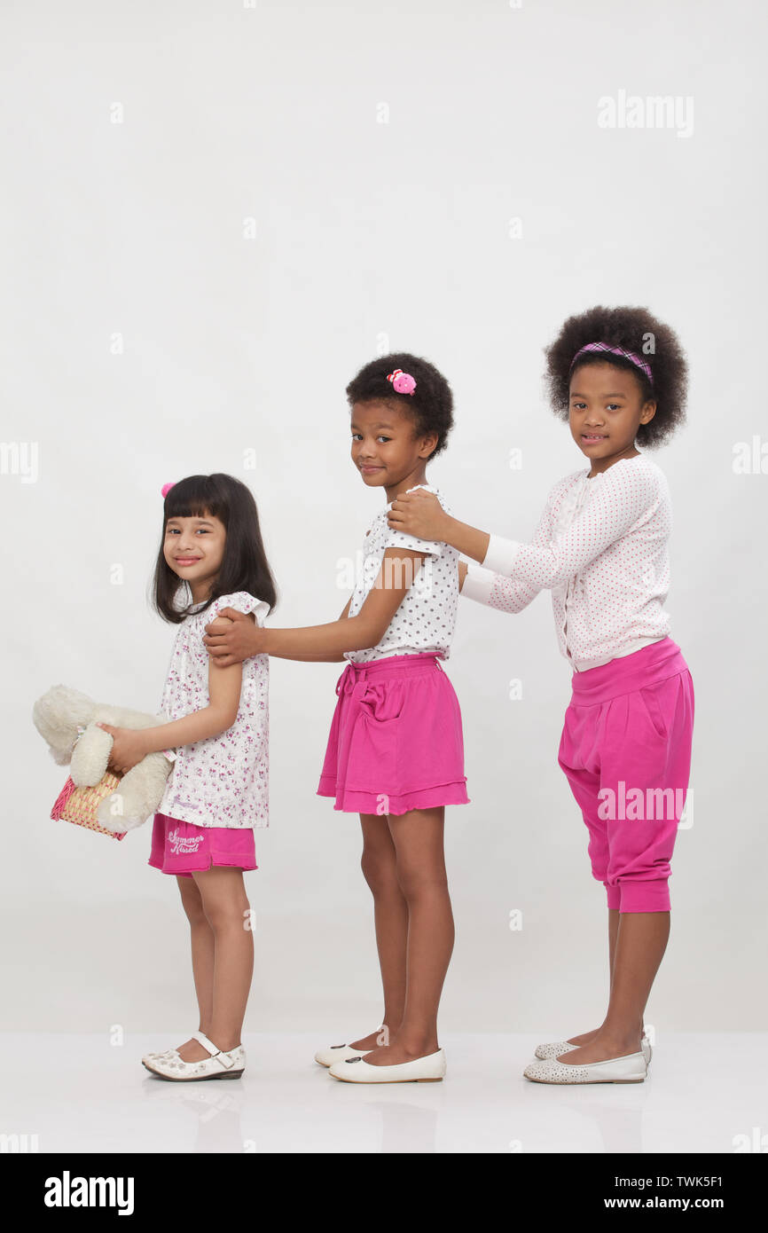 Portrait of three girls standing in a row Stock Photo - Alamy