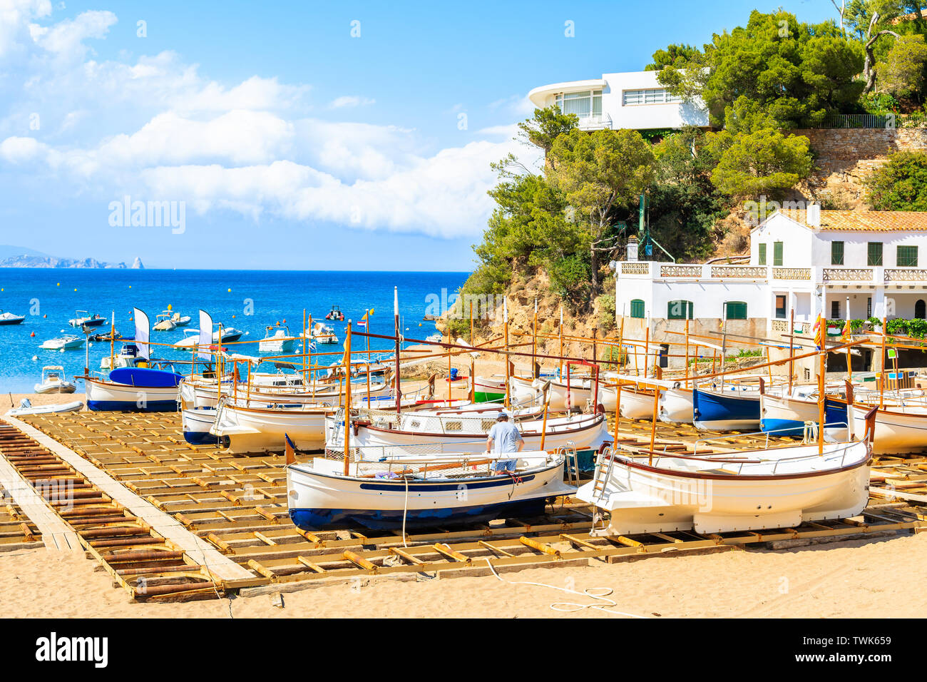 Traditional fishing boats on Sa Riera beach with sea and village houses ...
