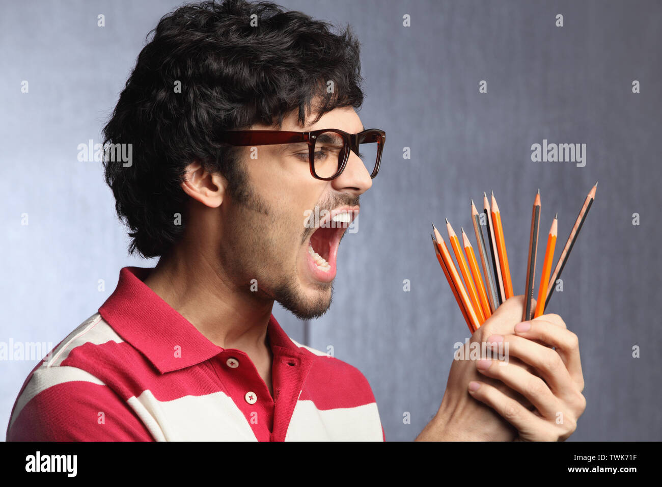 Man holding pencils and shouting Stock Photo - Alamy