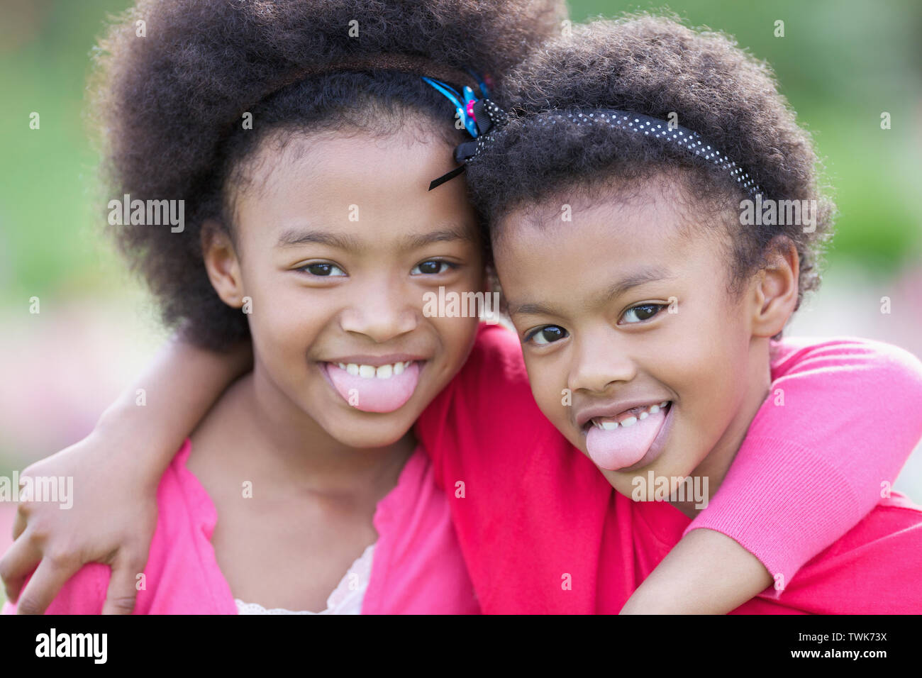 Two girls sticking their tongues out Stock Photo - Alamy