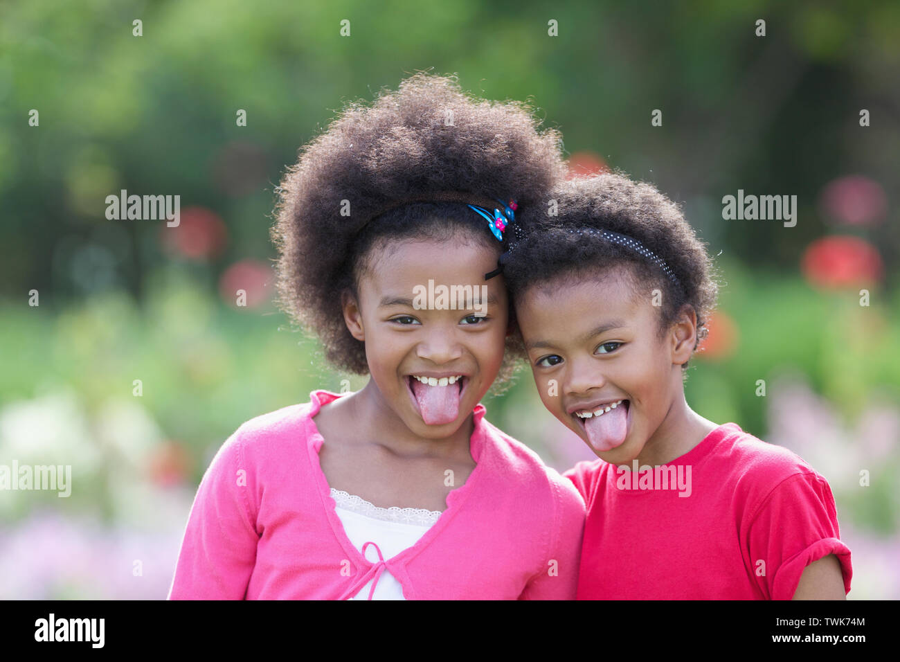 Portrait of two girls sticking their tongues out Stock Photo - Alamy