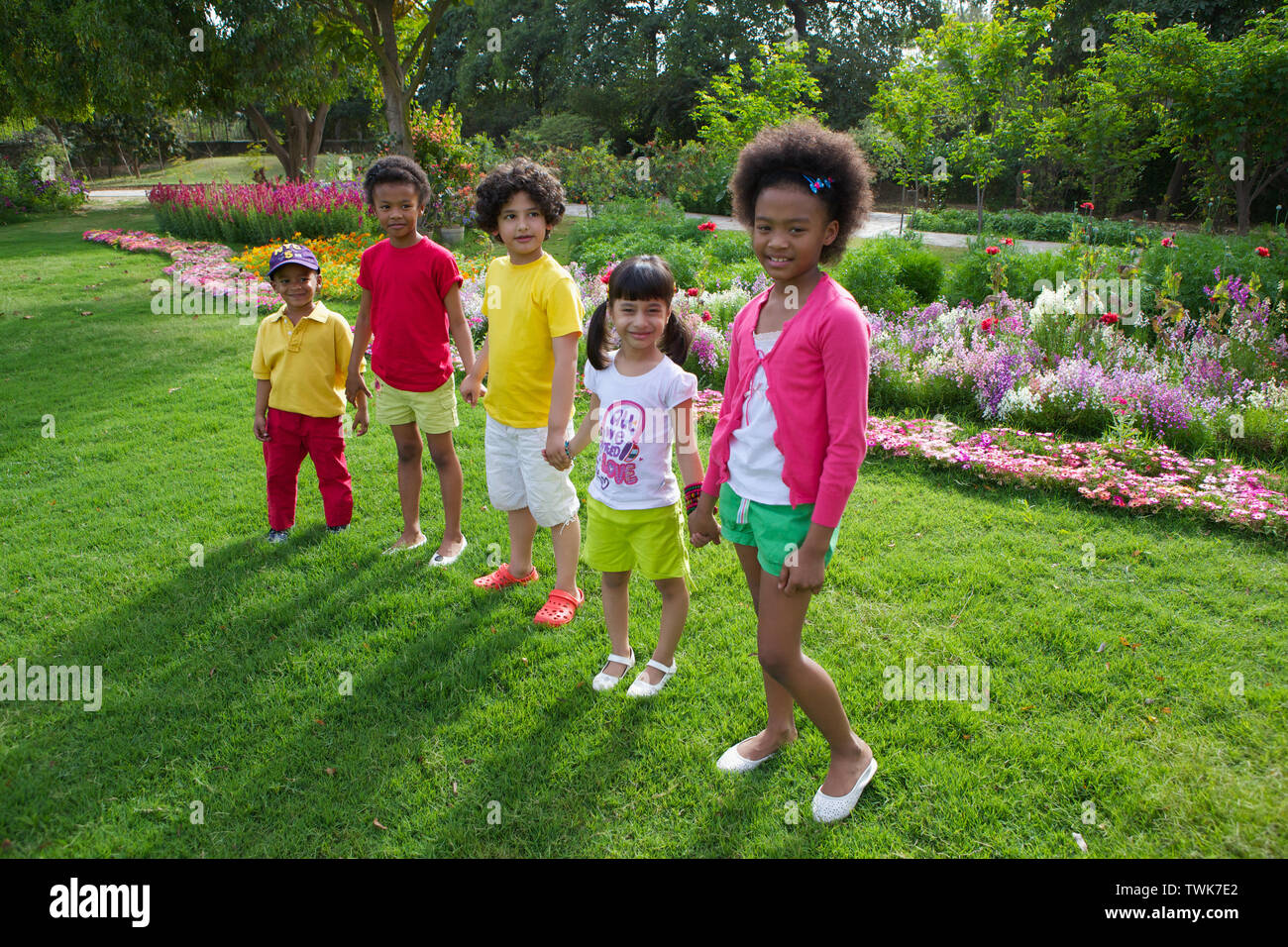 Children standing in a lawn Stock Photo - Alamy