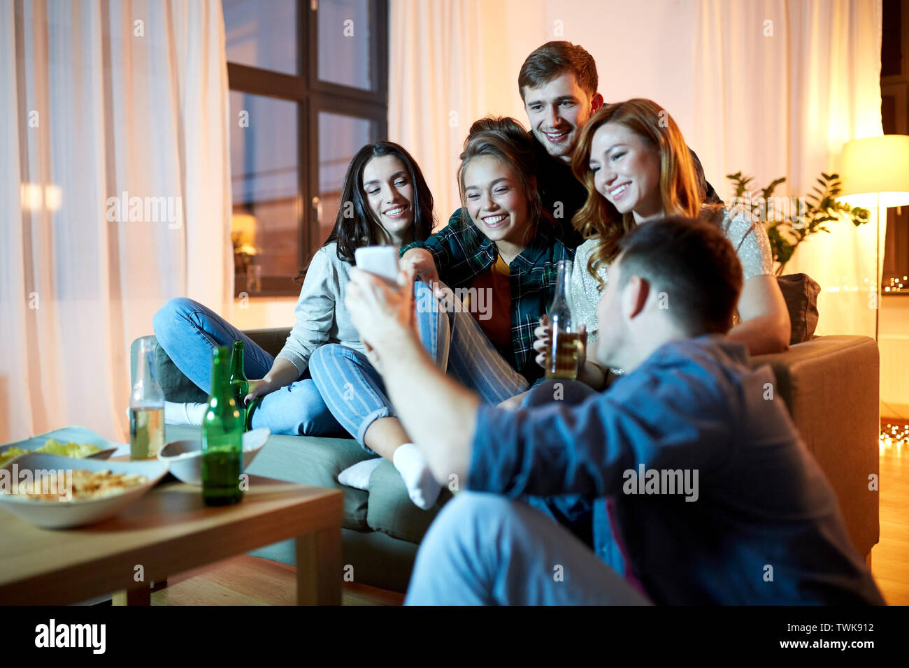 happy friends with smartphone at home party Stock Photo - Alamy