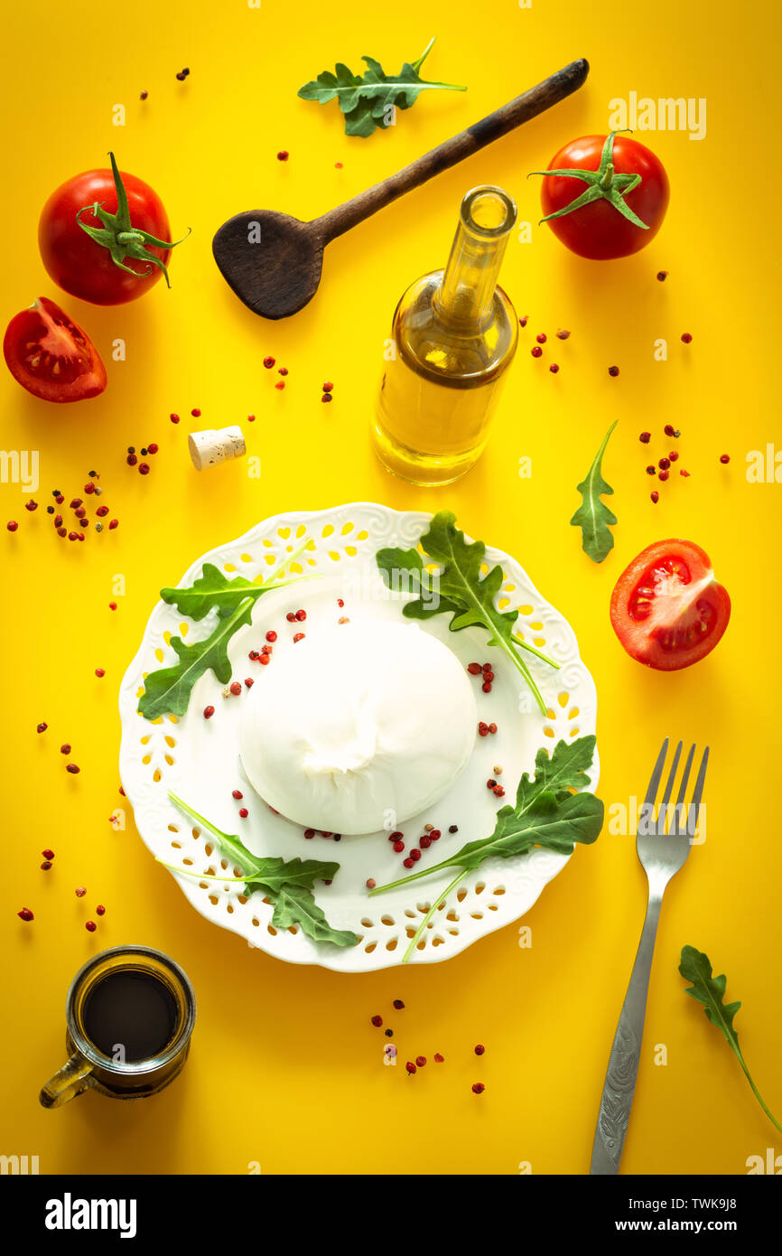 Burrata, Italian cheese with tomatoes, spices, argugula and olive oil ...