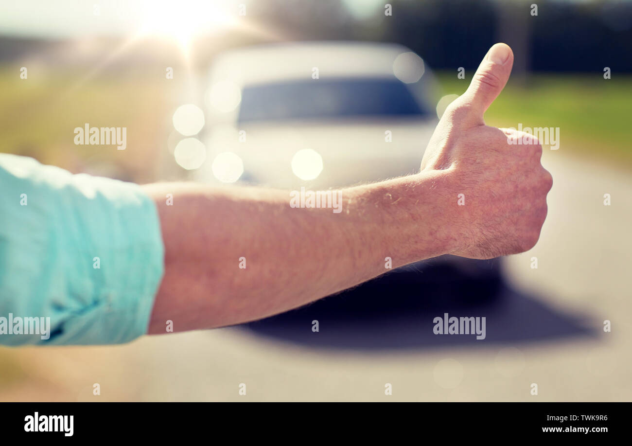 man hitchhiking and stopping car with thumbs up Stock Photo - Alamy