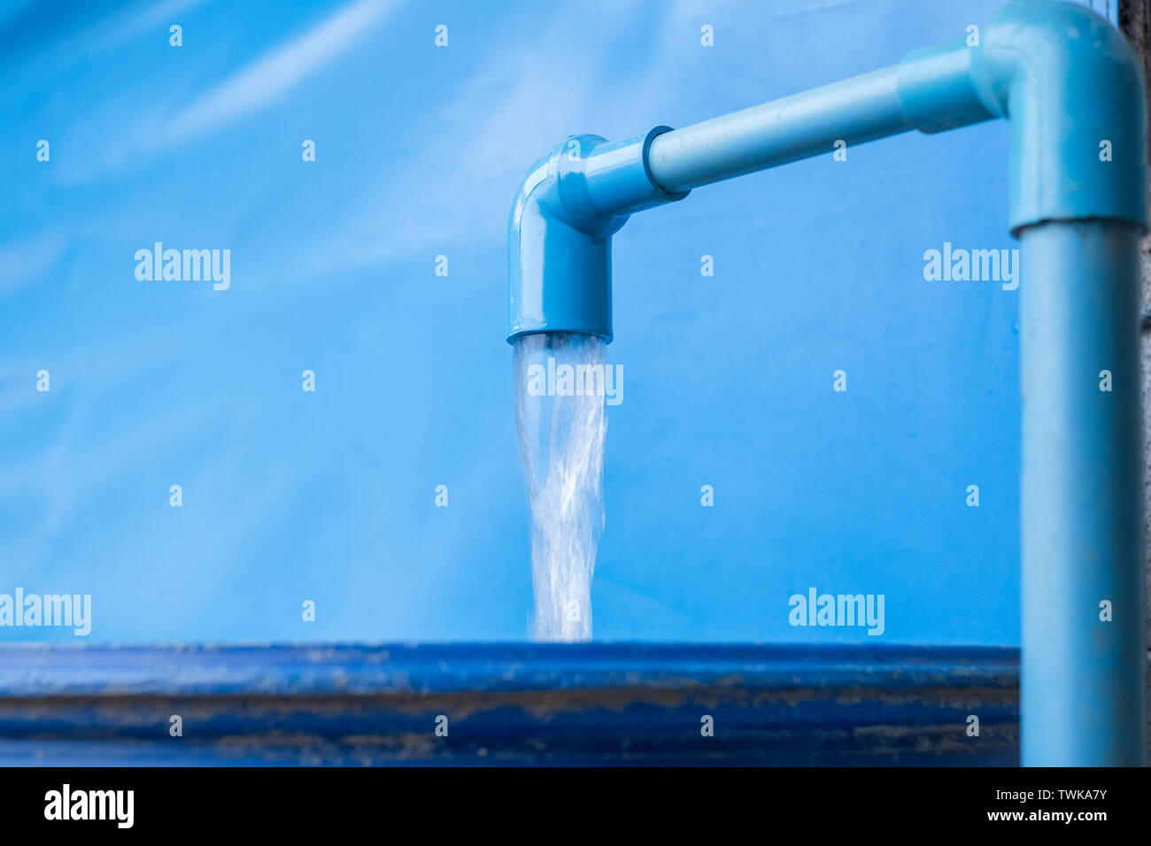 Blue pvc pipe with flowing water in bucket from groundwater Stock Photo ...