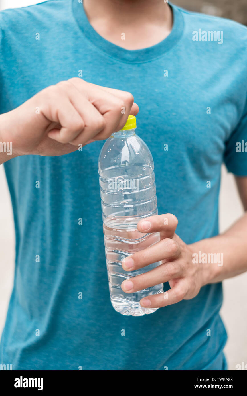Hand man opening lid bottle drinking water ,after the exercise is ...