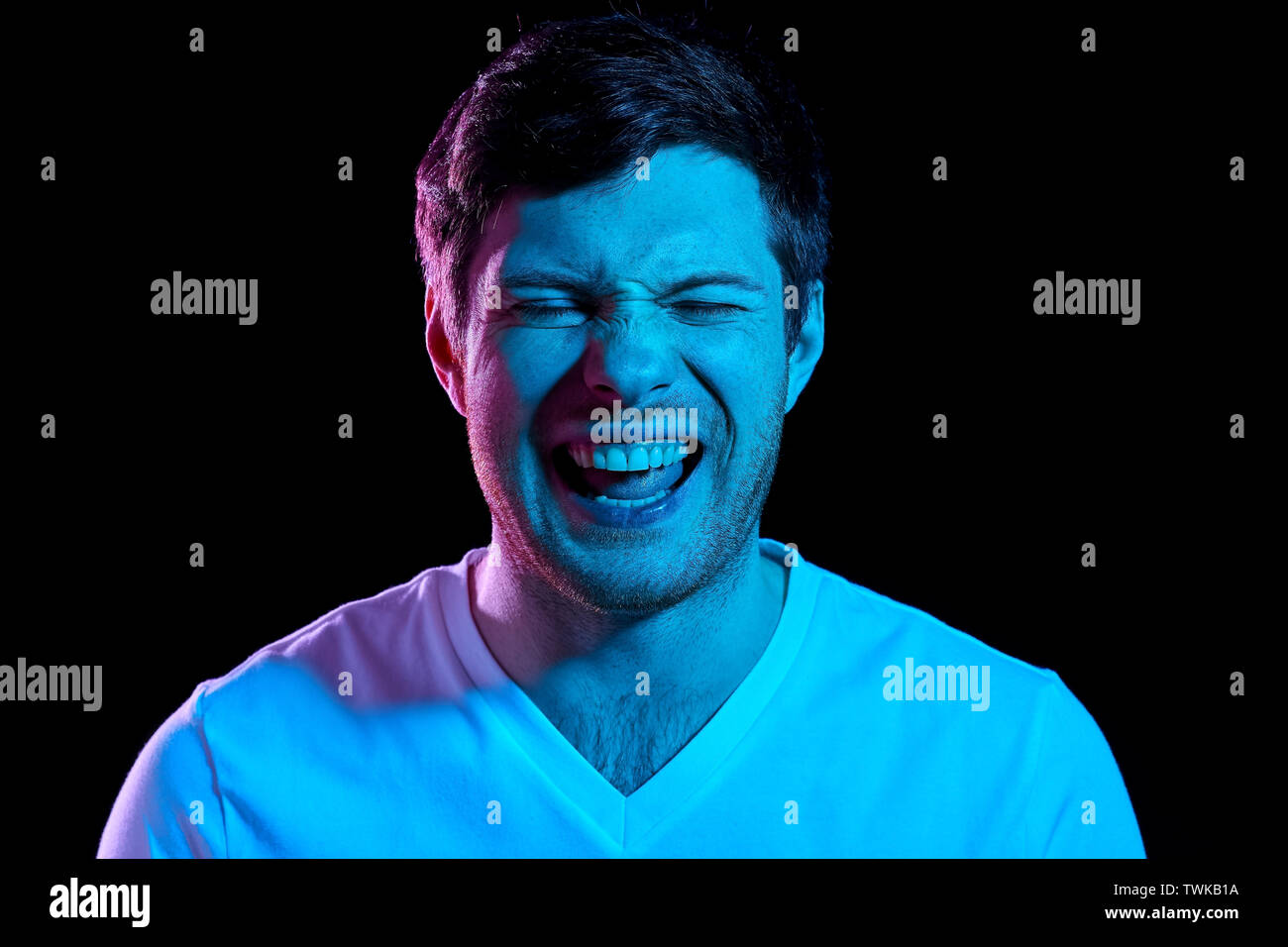 man laughing over neon lights in dark room Stock Photo - Alamy