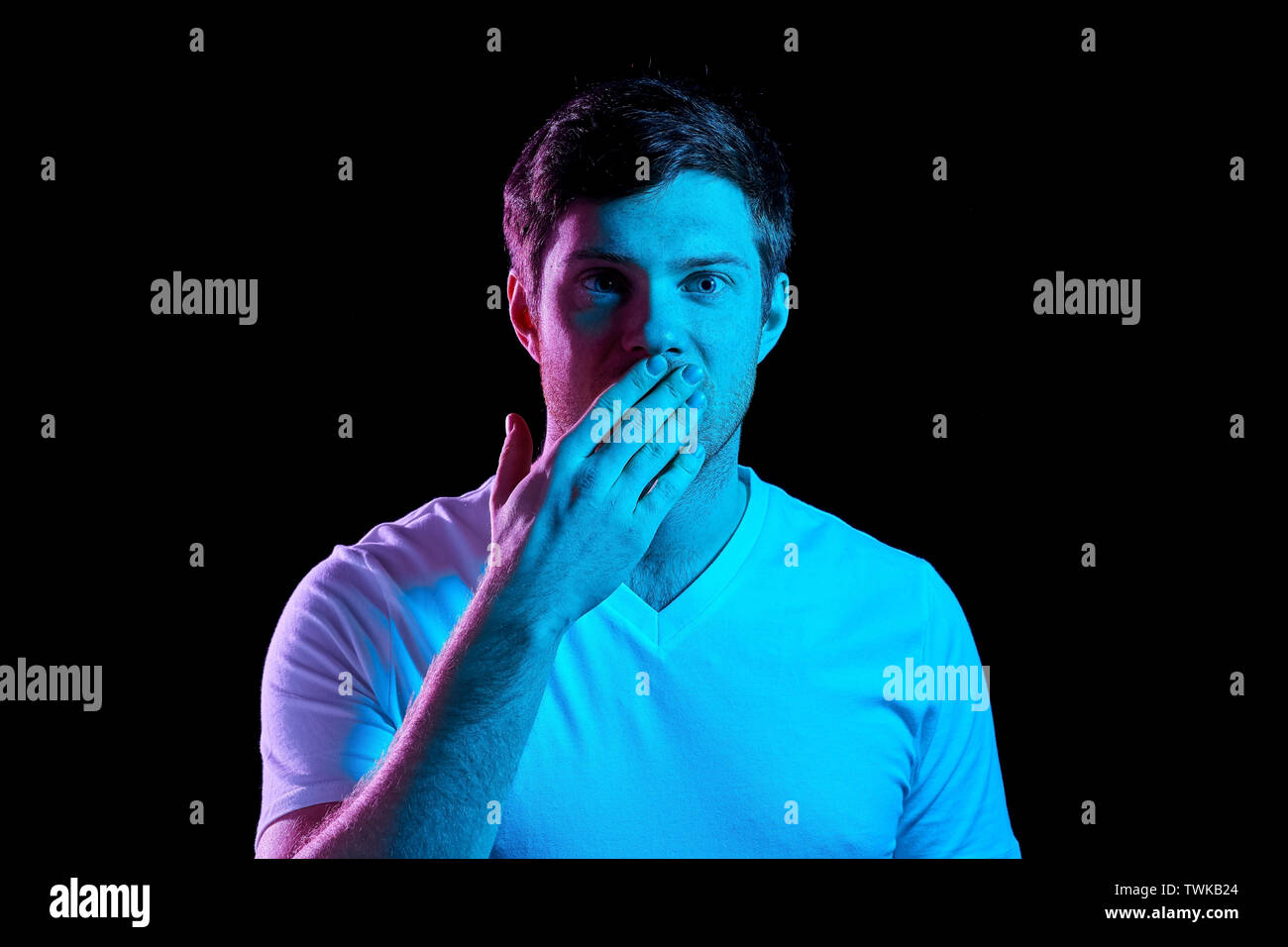 man covering his mouth by hand in neon lights Stock Photo - Alamy