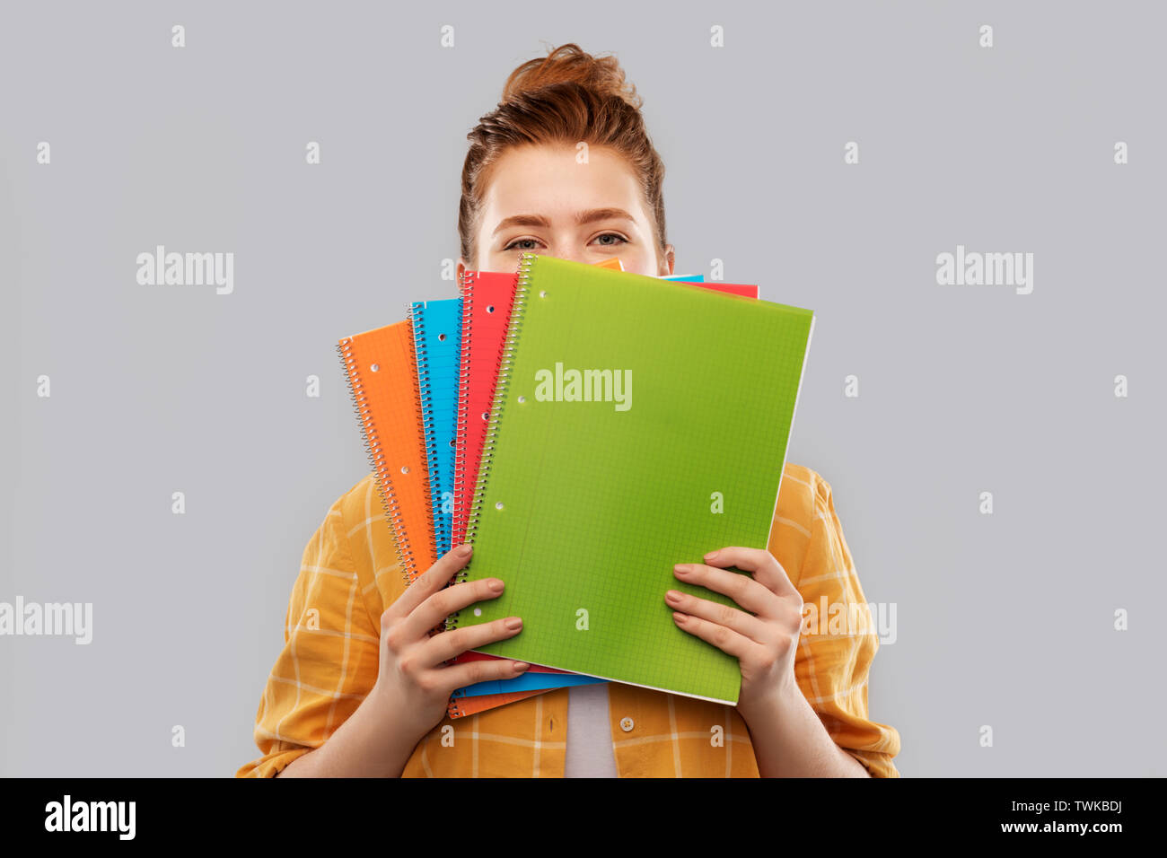 teenage student girl hiding behind notebooks Stock Photo - Alamy