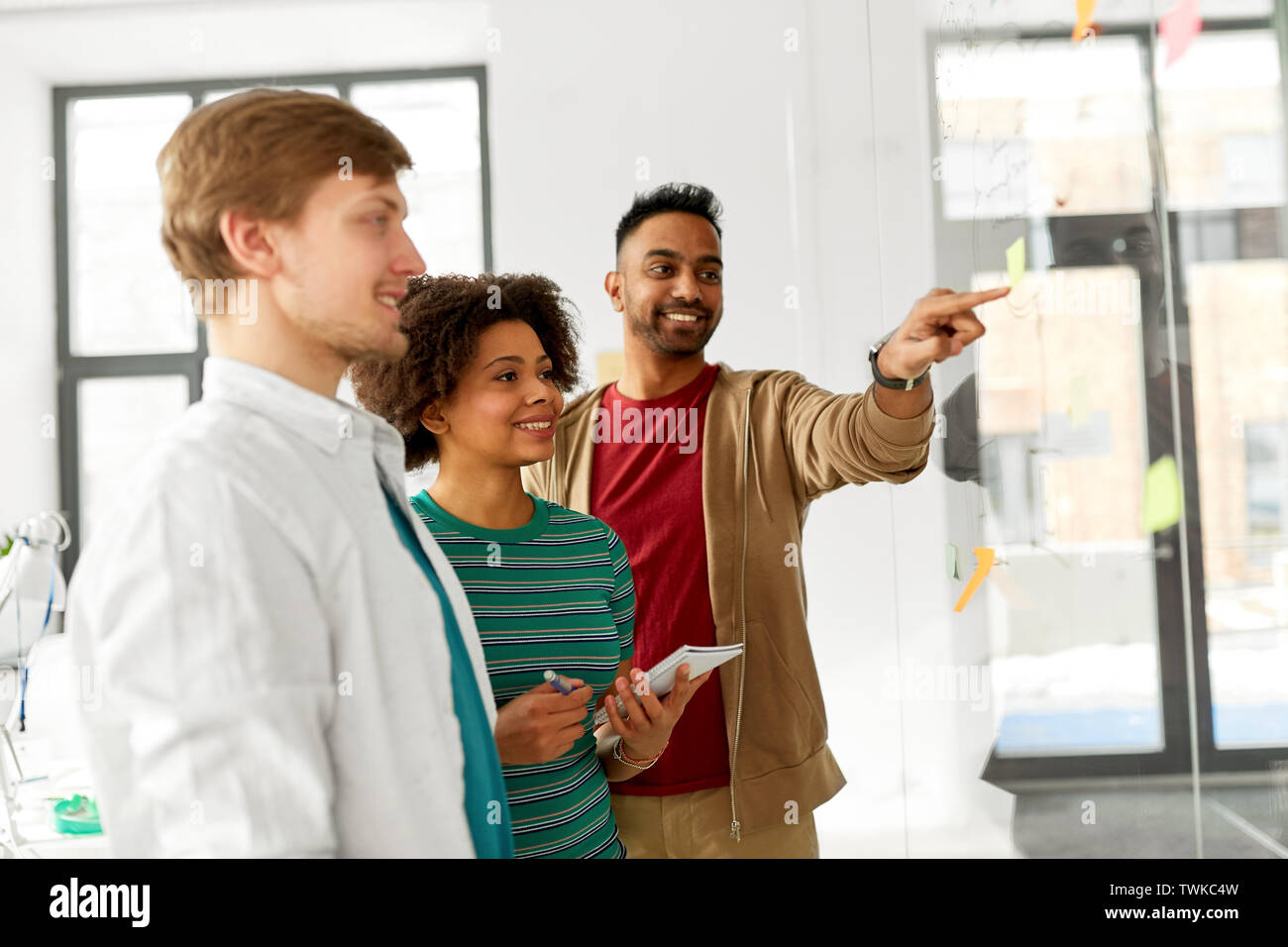 Smiling creative team looking sketch hi-res stock photography and ...