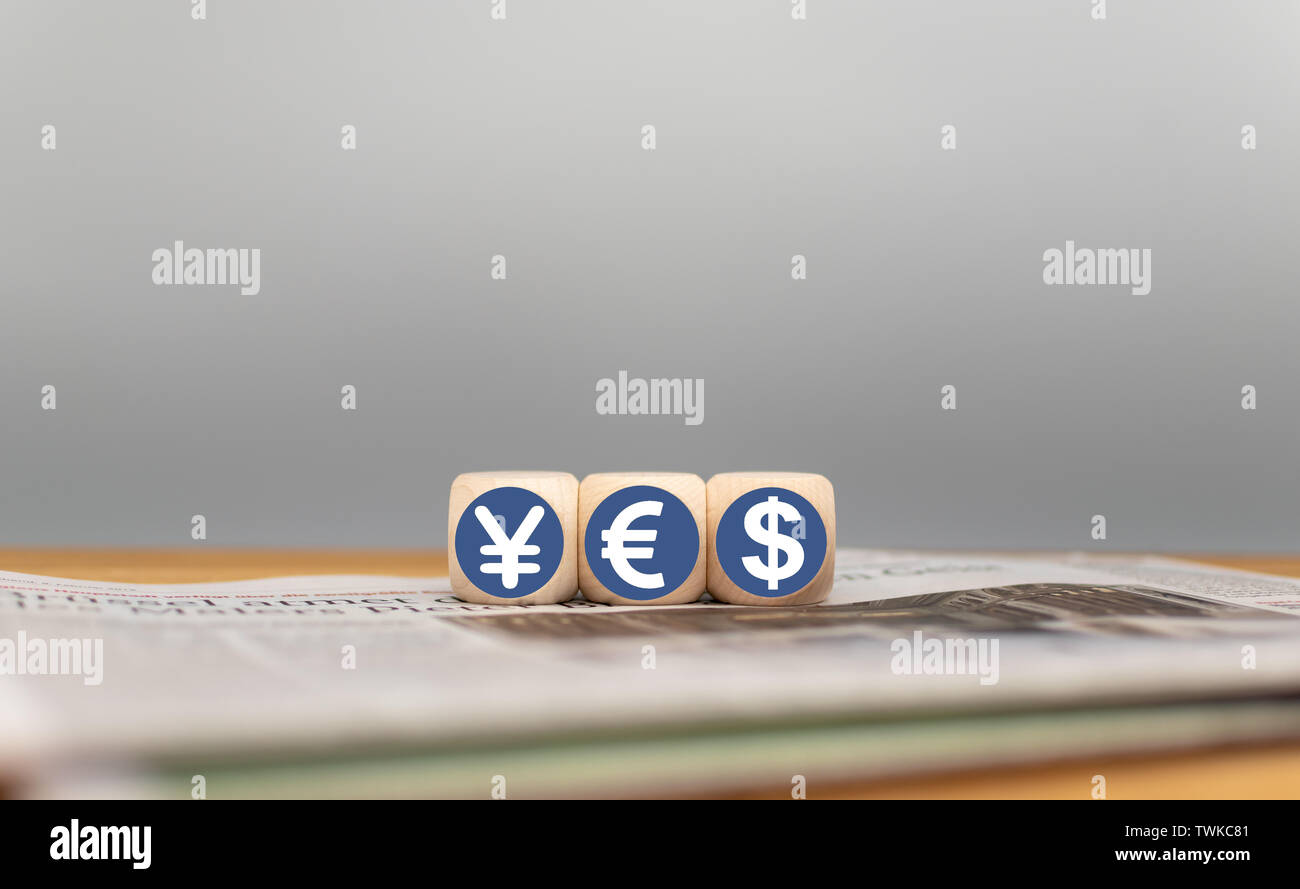 Currency symbols form the word "YES" on cubes placed on a newspaper ...