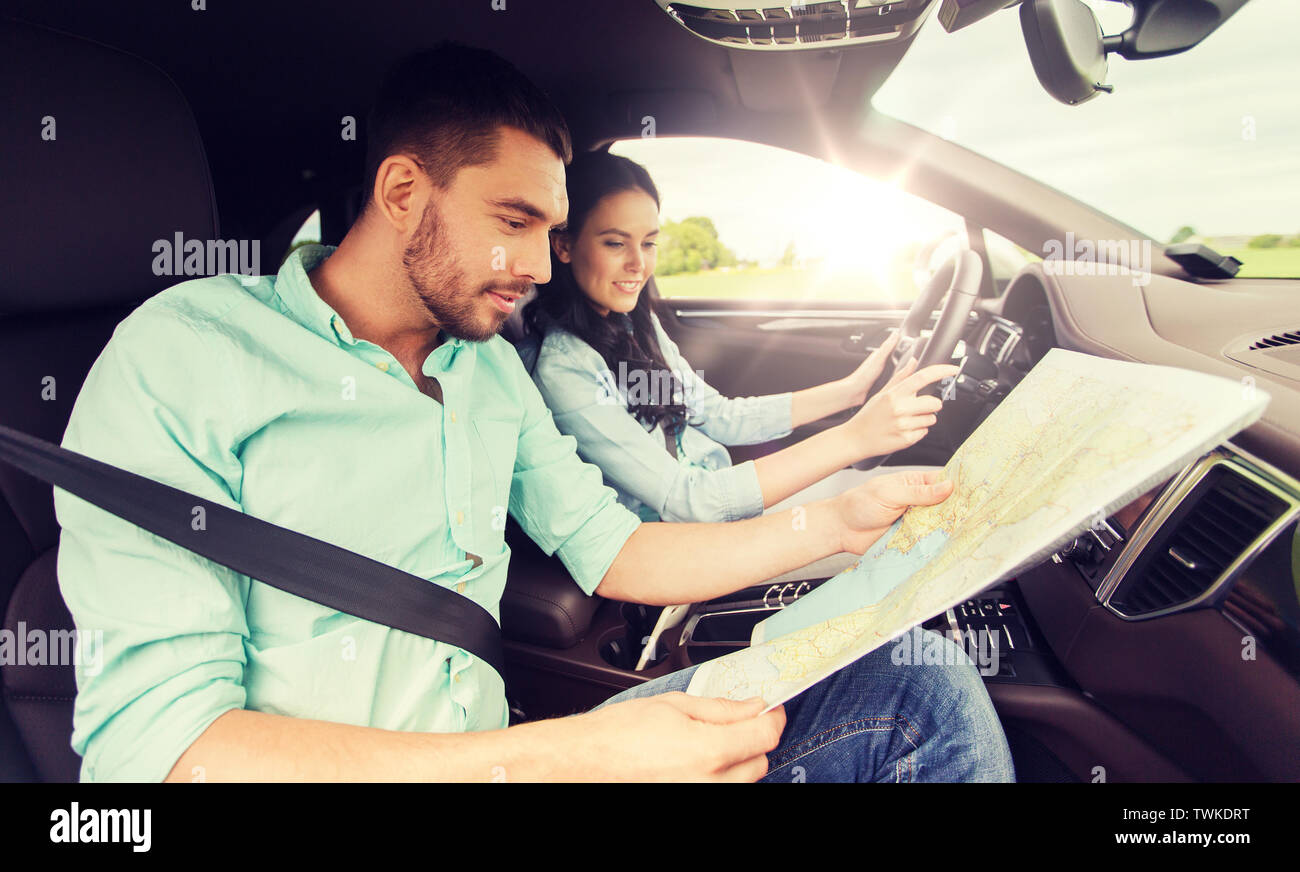 happy man and woman with road map driving in car Stock Photo - Alamy